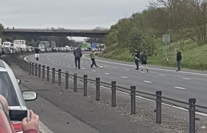 Group play football in middle of M4 while firefighters tackle blaze