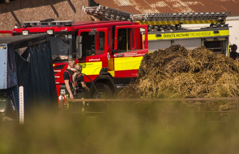 A crappy job: Firefighters stand on 50 tonne mound of burning manure in ...