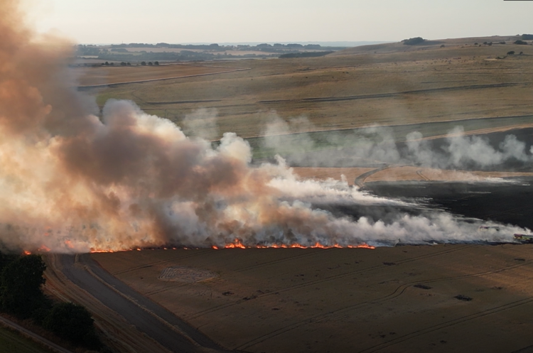 At least 60 firefighters battle huge field fire — just two miles from ...
