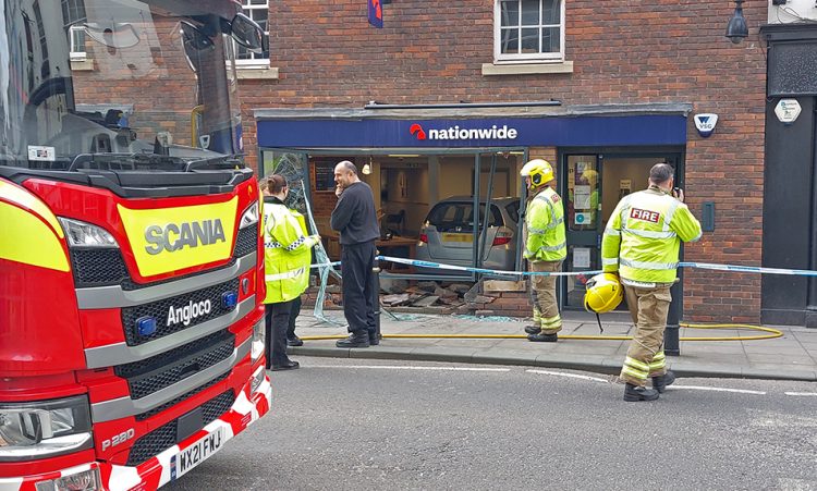 Driver hospitalised after smashing car through Nationwide's window